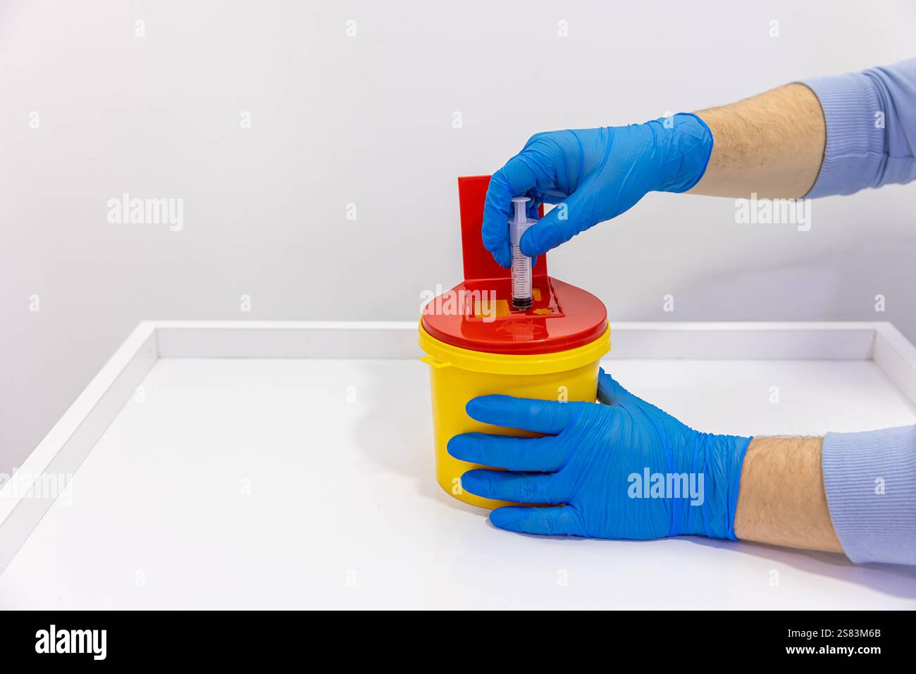 Old medicine syringes thrown into a medical waste container. The ...