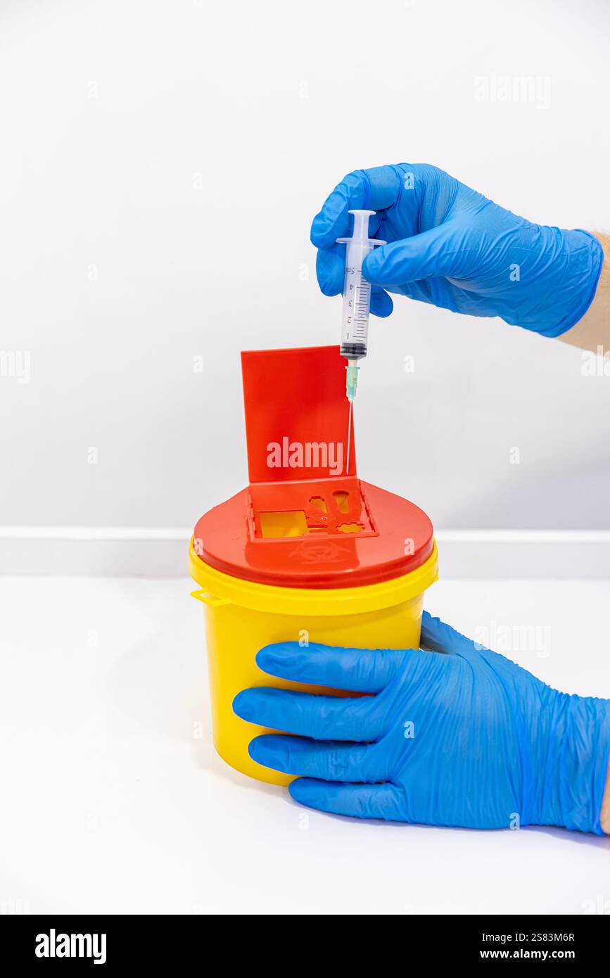 Old medicine syringes thrown into a medical waste container. The ...