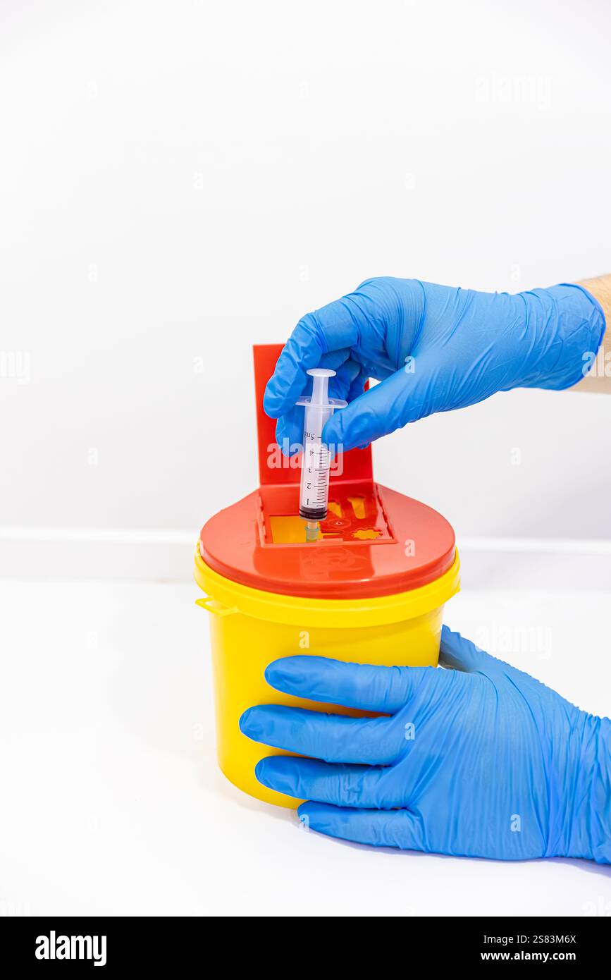 Old medicine syringes thrown into a medical waste container. The ...