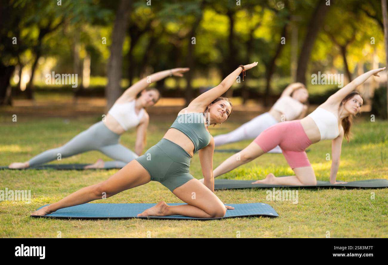 Group of young women doing stretching in park Stock Photo - Alamy