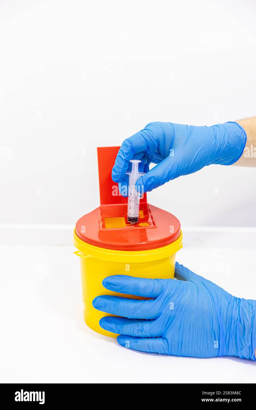 Old medicine syringes thrown into a medical waste container. The ...