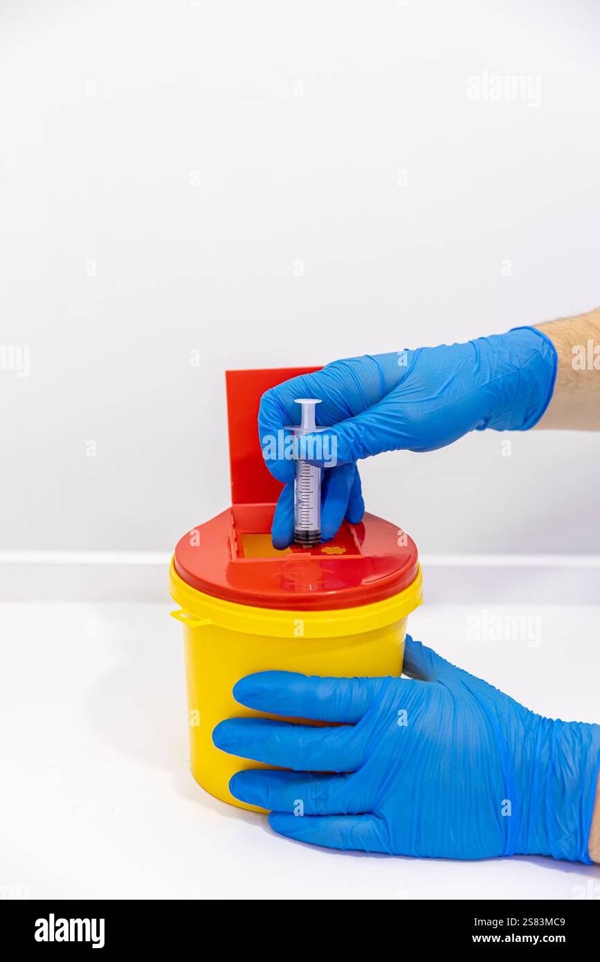 Old medicine syringes thrown into a medical waste container. The ...