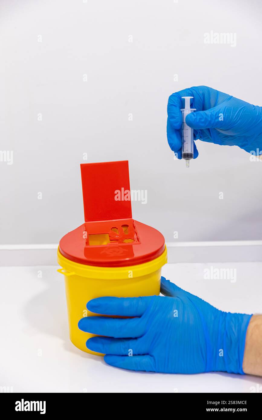 Old medicine syringes thrown into a medical waste container. The ...