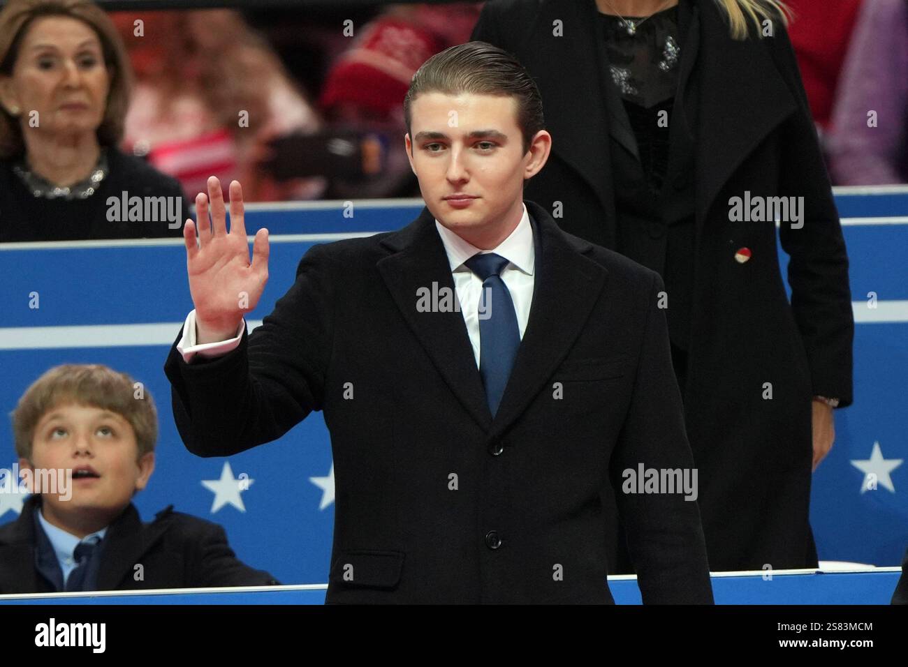 Barron Trump waves as he arrives at an indoor Presidential Inauguration ...