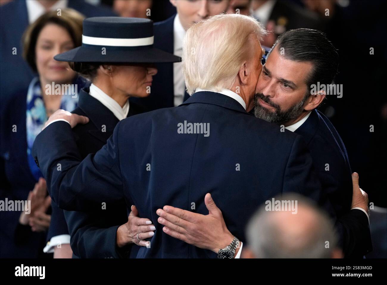 President Donald Trump hugs Donald Trump Jr., as he puts his arm around ...