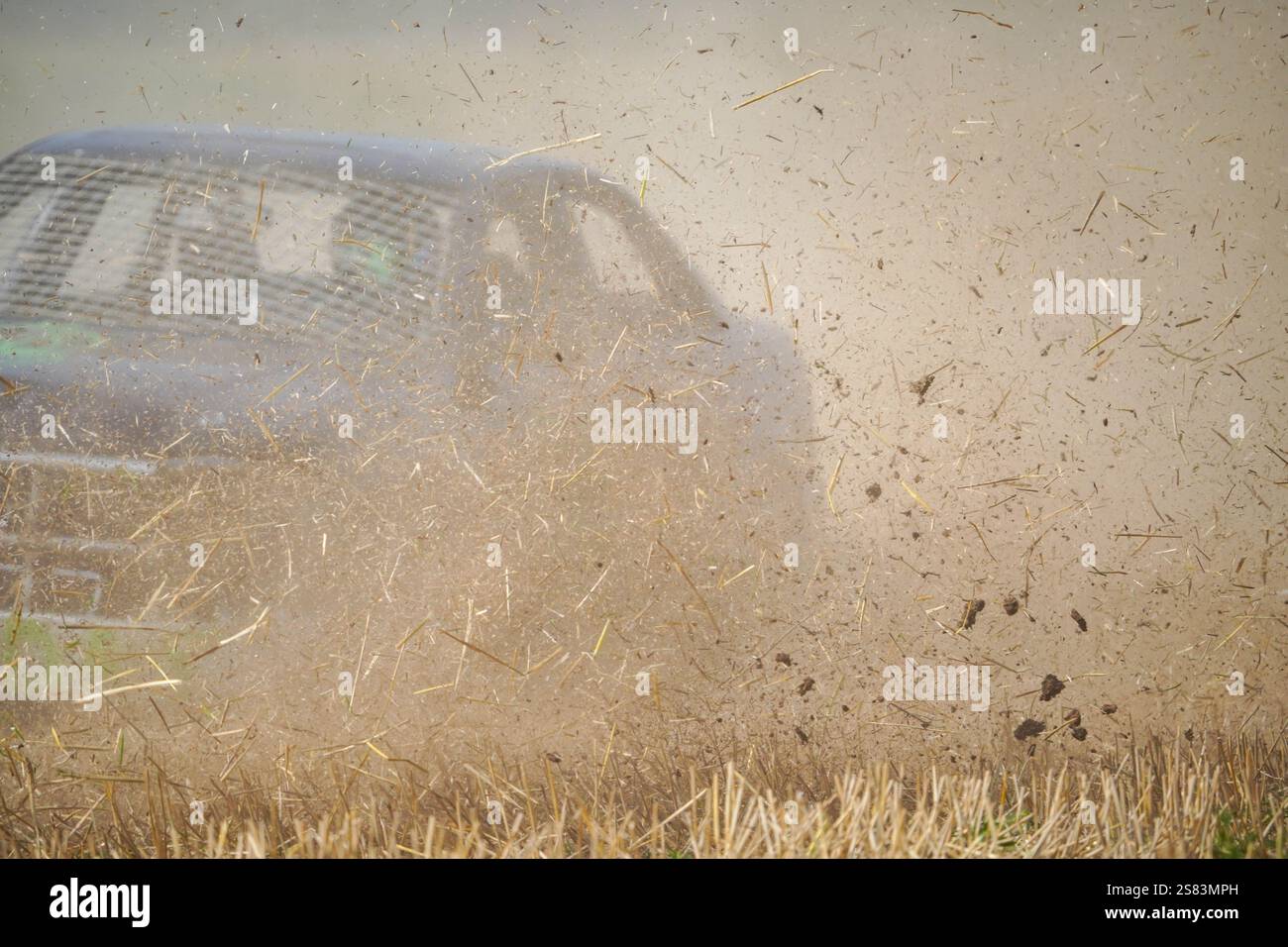 A car is driving through a muddy field, leaving a trail of dirt behind ...