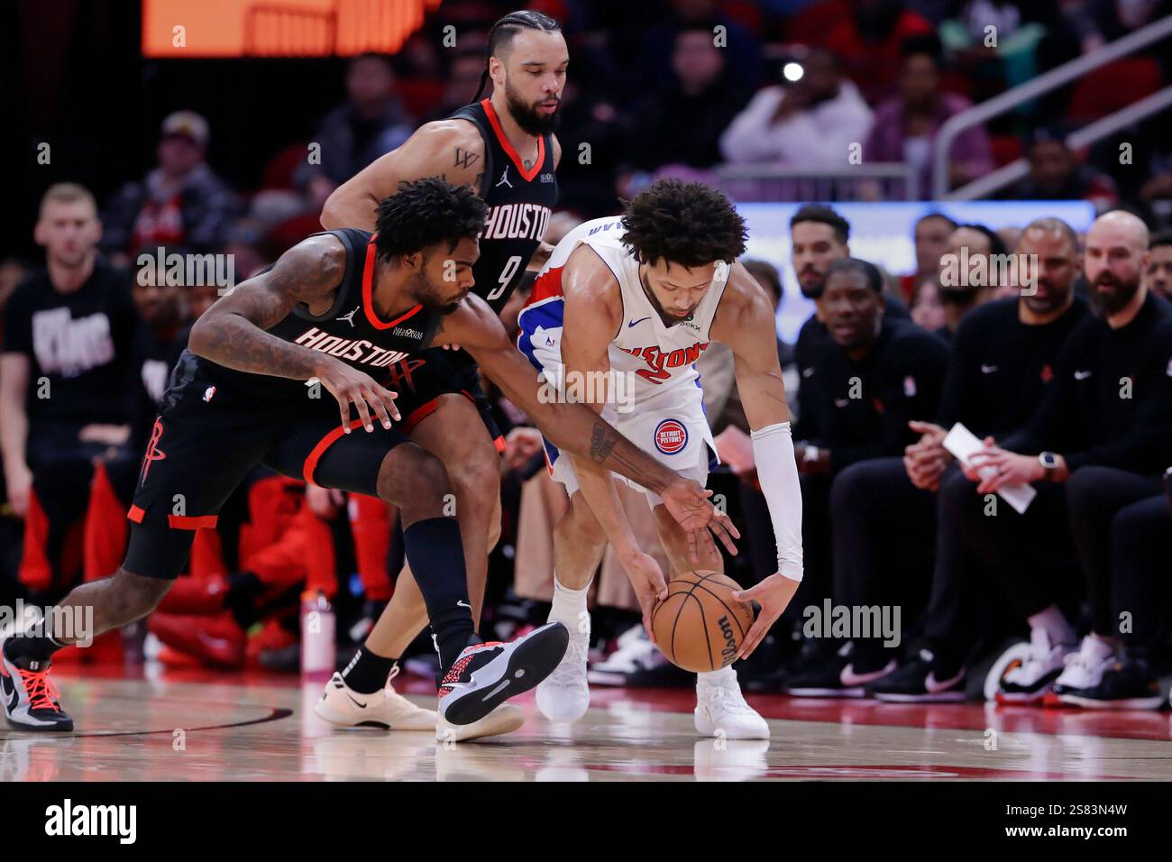 Detroit Pistons guard Cade Cunningham, right, scoops up the ball from ...