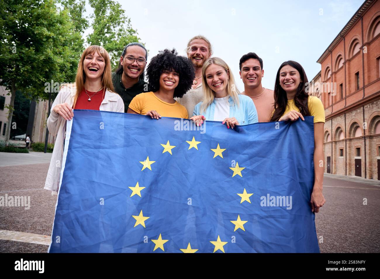Multiracial group of friends holding the European Union flag with pride ...