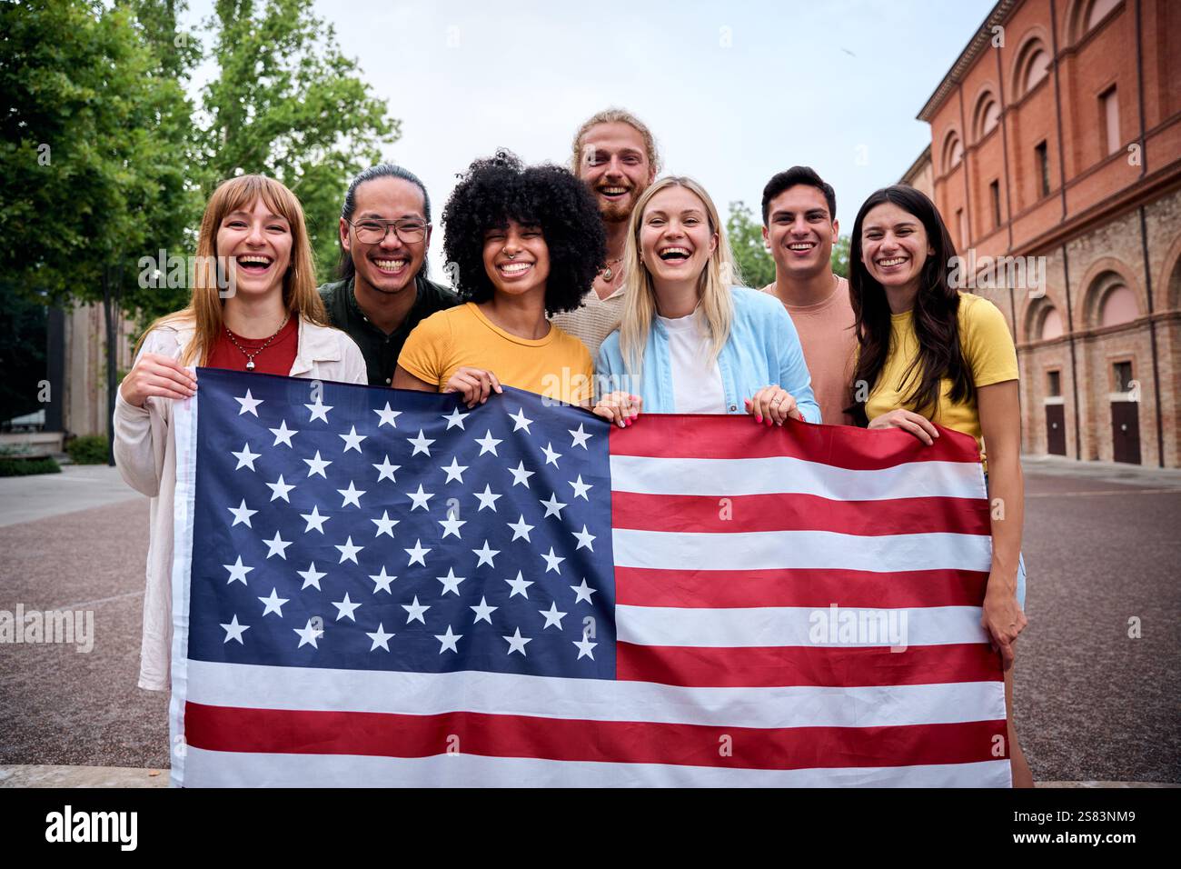 Multiracial group of friends holding American flag with pride ...