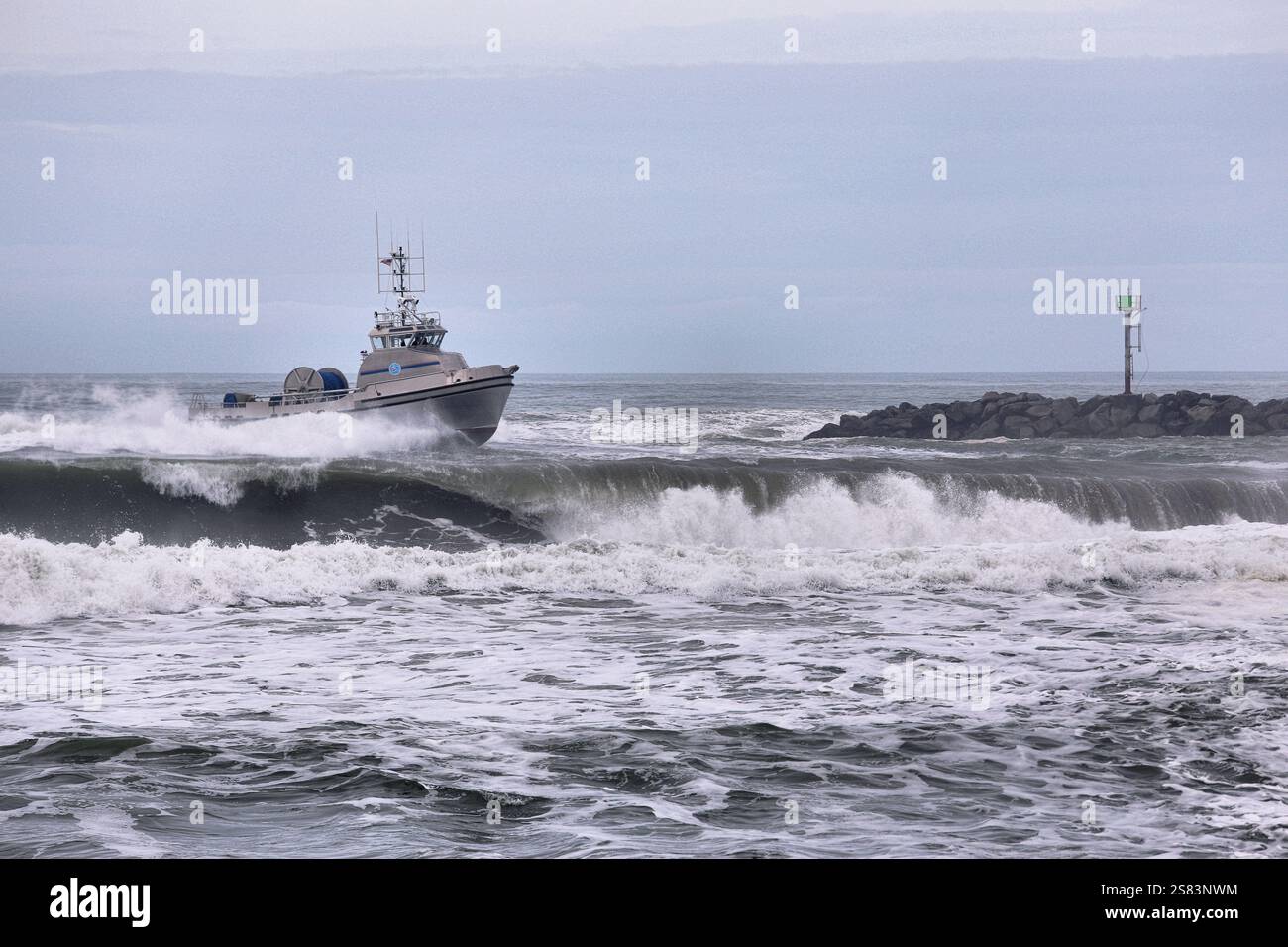 A boat returns to harbor amid very rough and dangerous seas Stock Photo ...