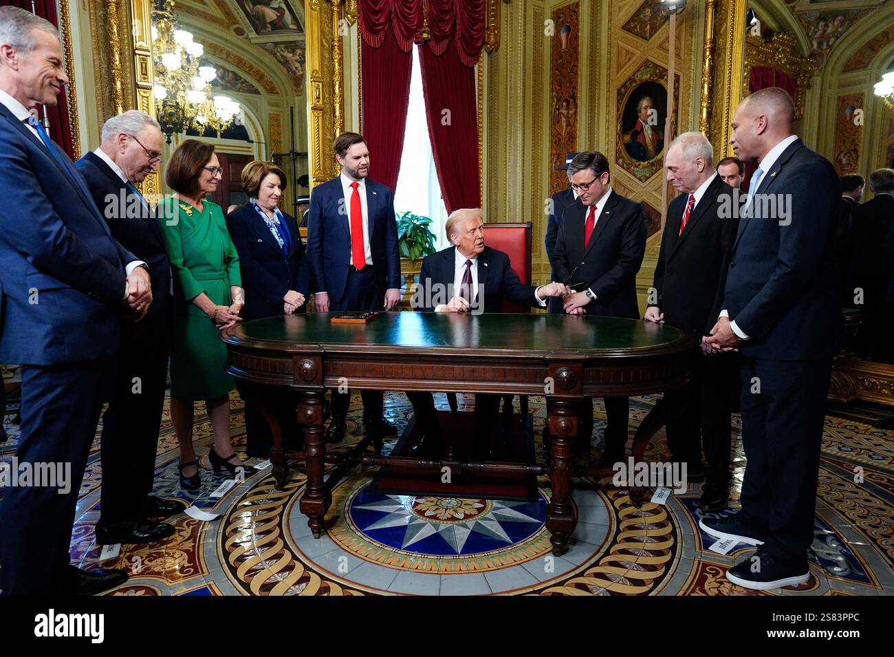 Newly sworn-in President Donald Trump takes part in a signing ceremony ...