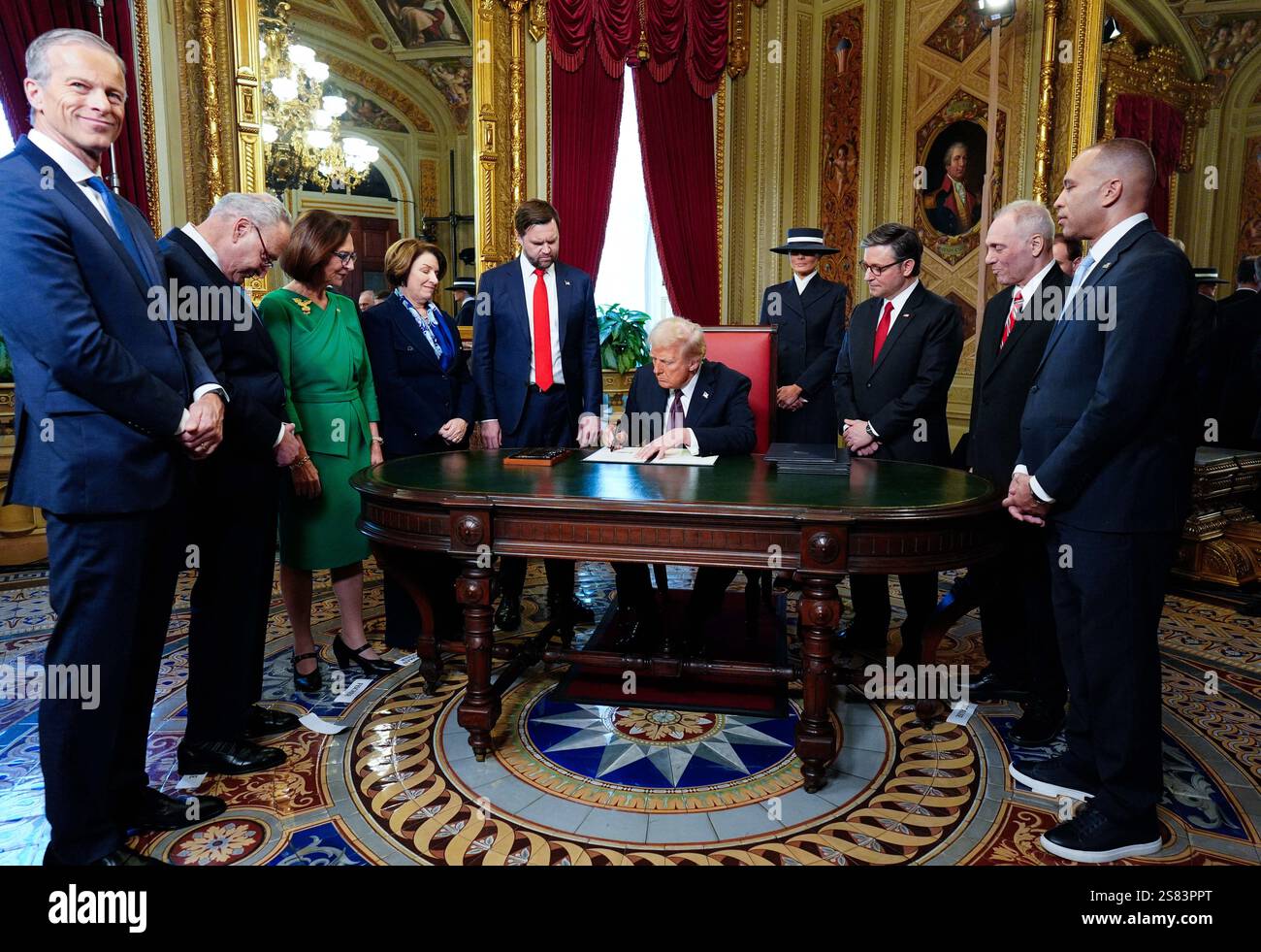 Newly sworn-in President Donald Trump takes part in a signing ceremony ...