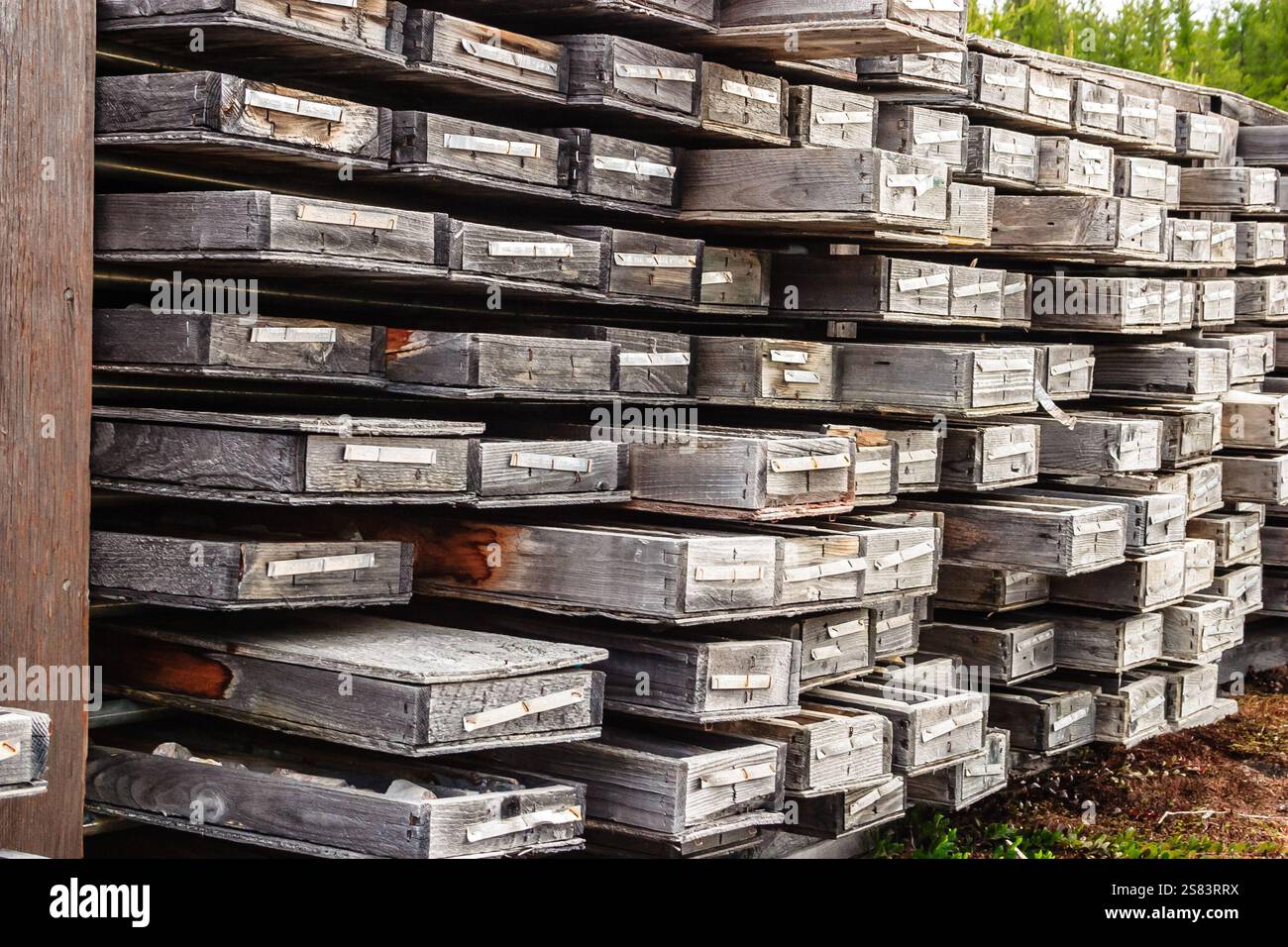 A stack of wooden crates are piled high. The crates are old and worn ...