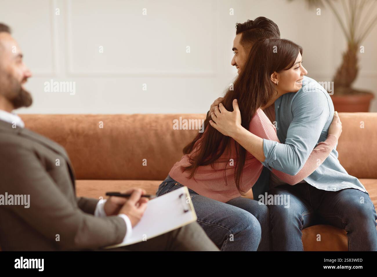 Happy couple hugging reconciling at therapy session in therapists ...