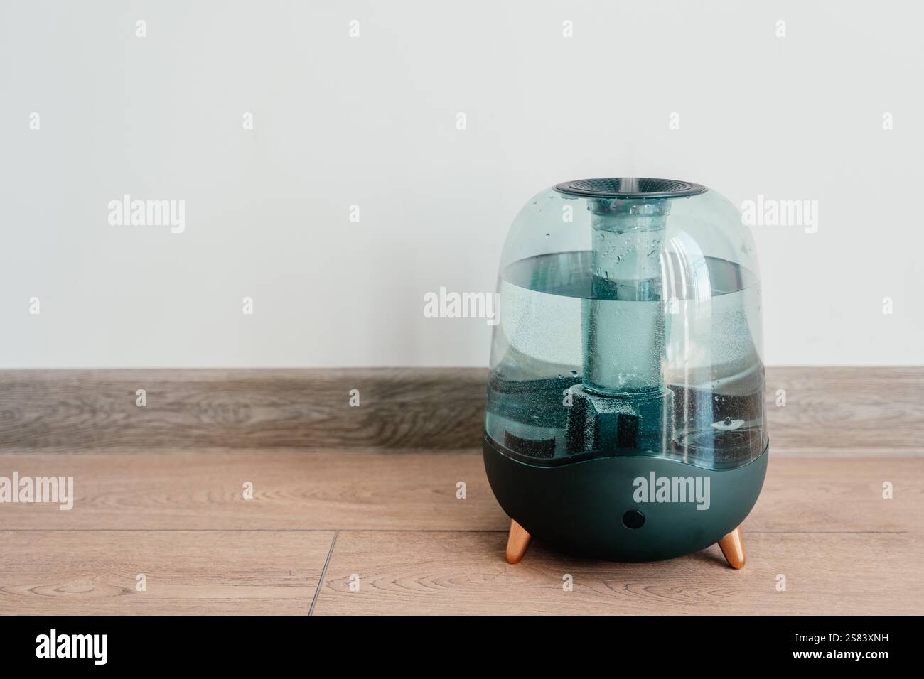 Modern air humidifier on a wall. Humidifier spreading steam into the ...