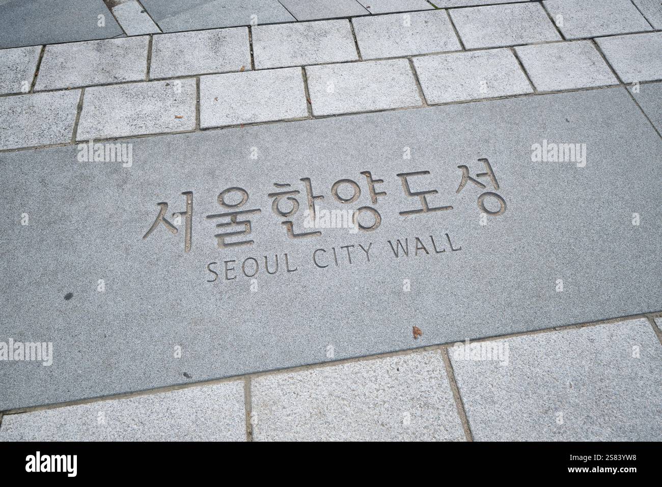A marker in the sidewalk where the wall used to be. At the Seoul City ...