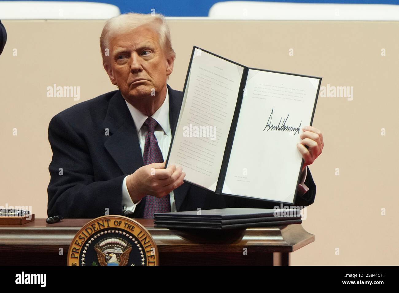 President Donald Trump holds up an executive orders after signing it at ...