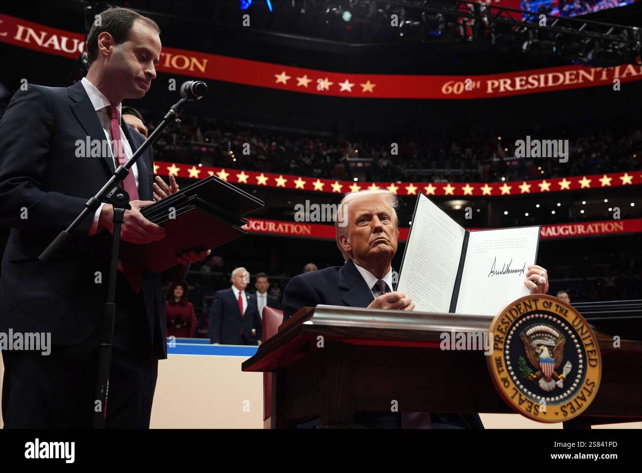 President Donald Trump signs an executive order as he attends an indoor ...