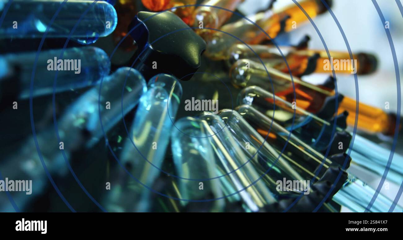 Image of circles moving over test tubes Stock Photo - Alamy