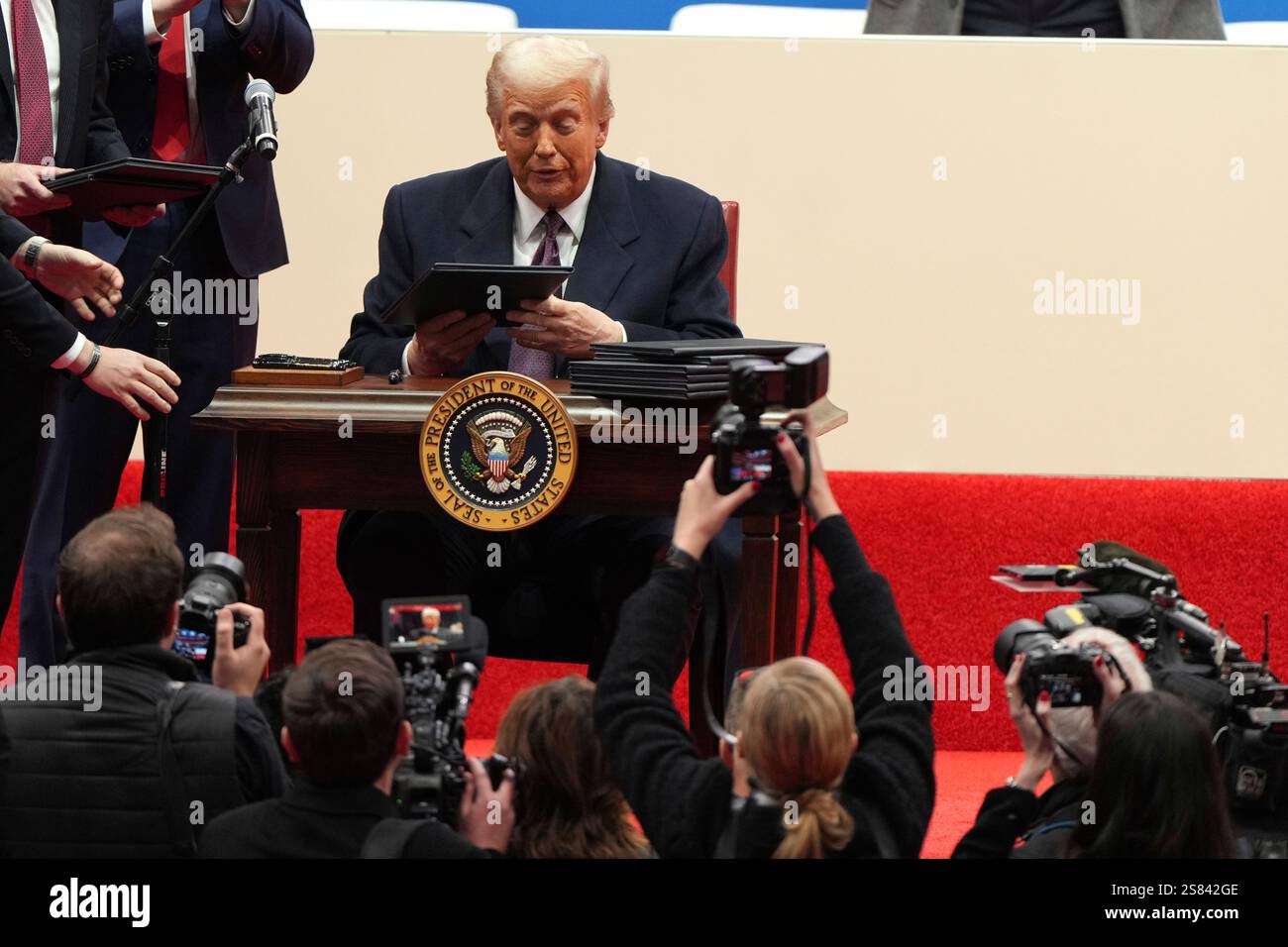 President Donald Trump signs executive orders at an indoor Presidential ...