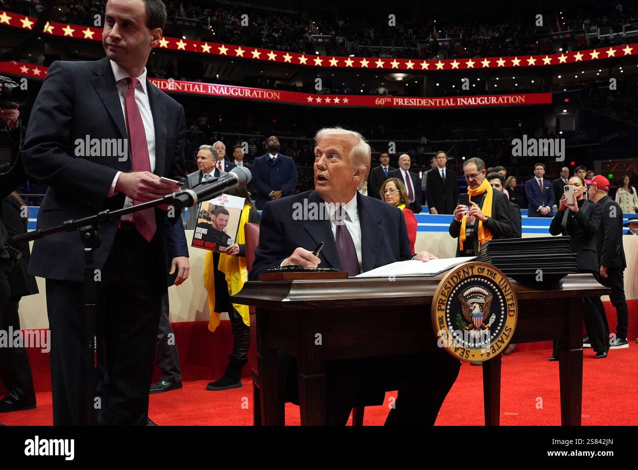President Donald Trump signs executive orders as he attends an indoor ...