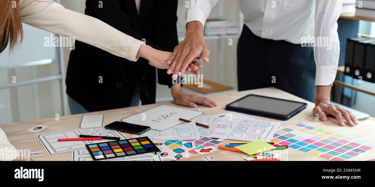 United UX UI design team placing hands together in support during a ...