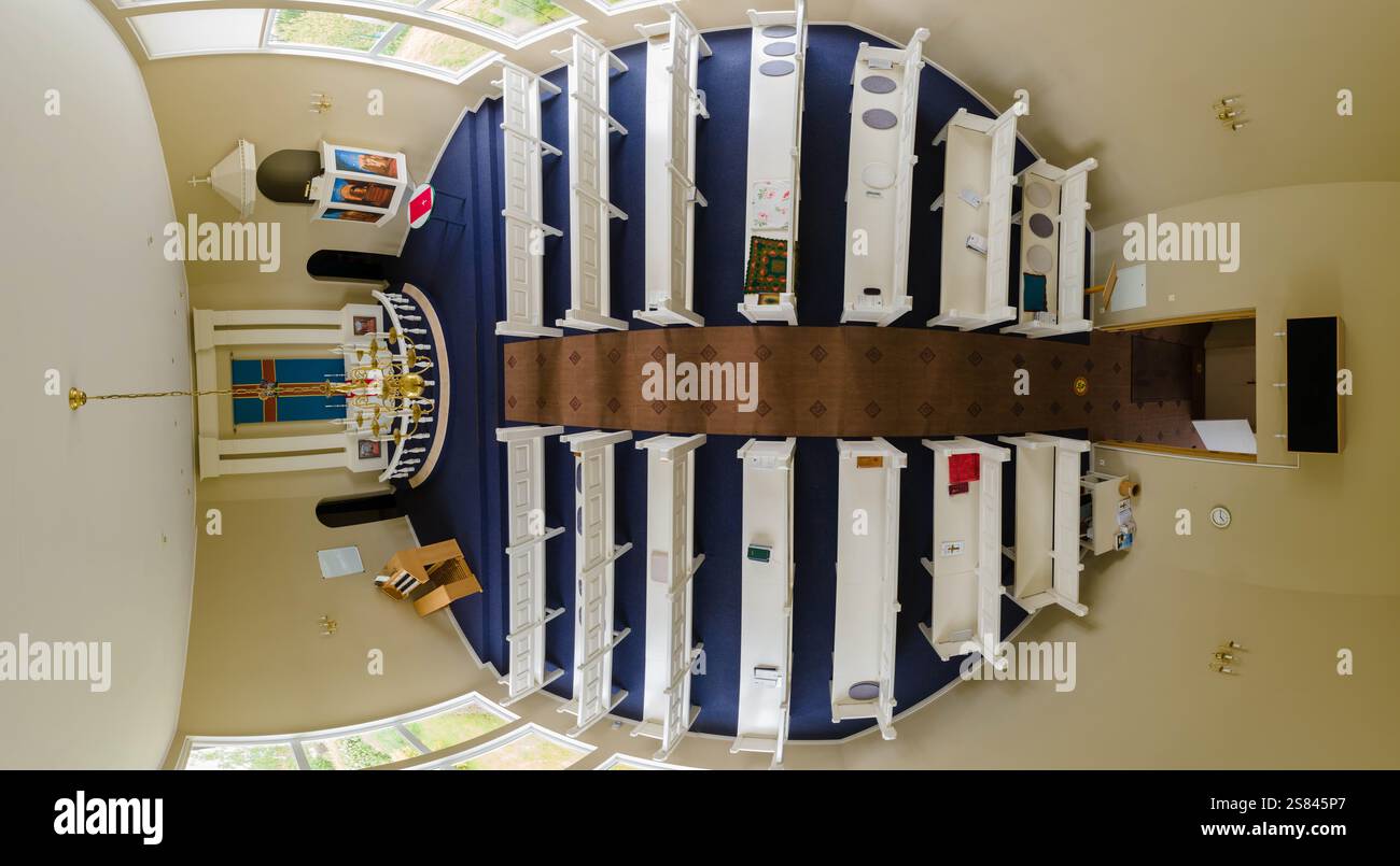 Interior of a small church viewed from above, featuring white pews ...