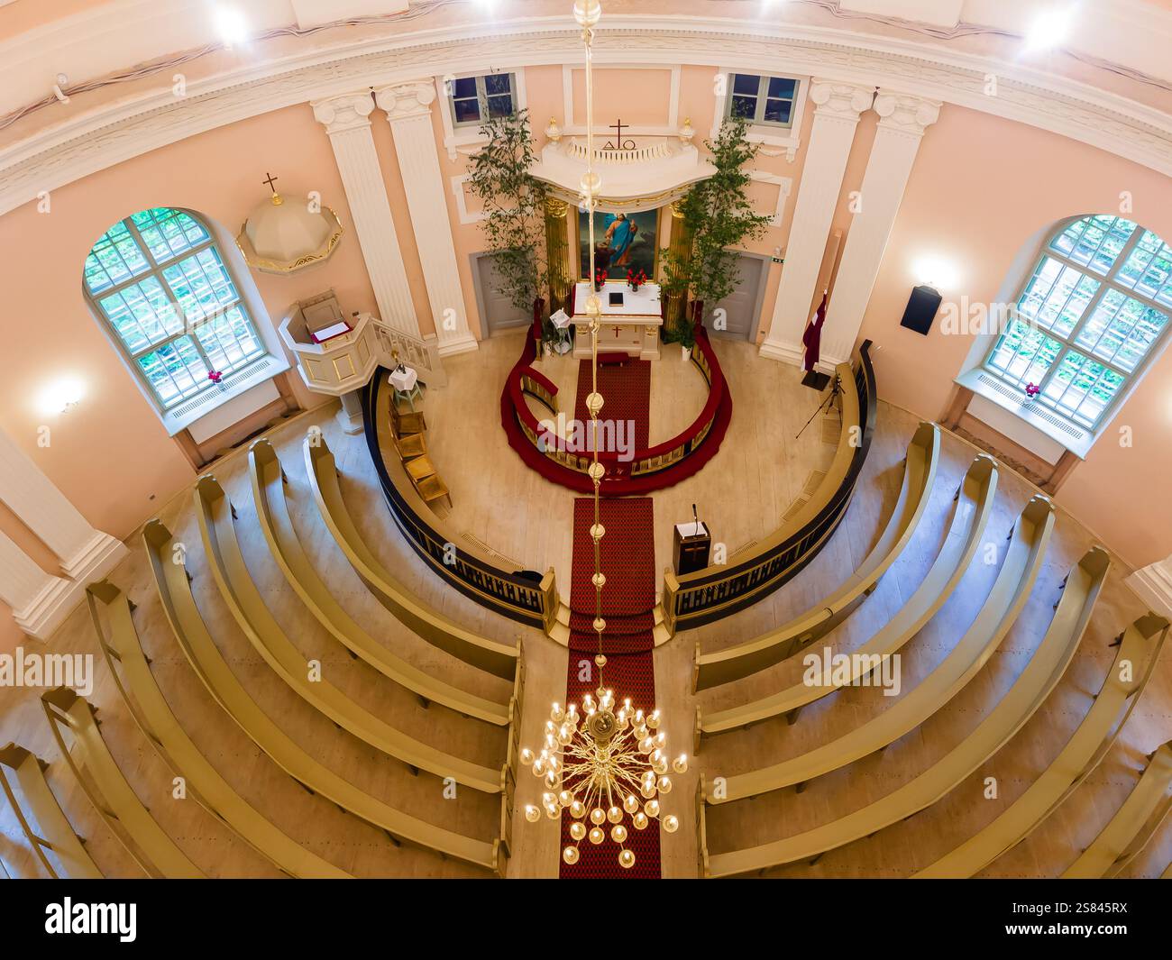 Church interior featuring curved pews, a red carpeted altar, a large ...