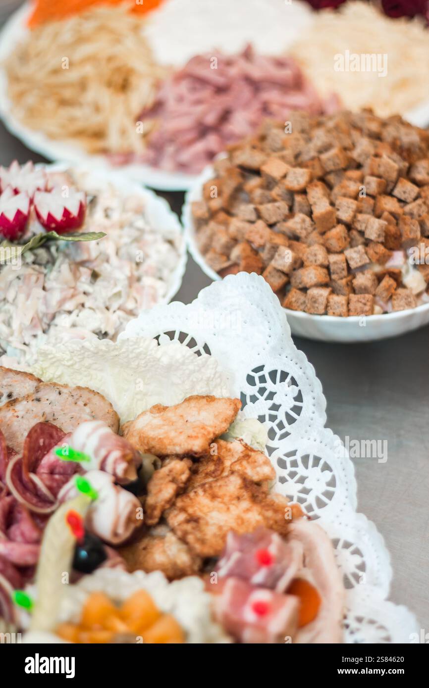 A table displays a variety of plated foods, including fried items, cold ...