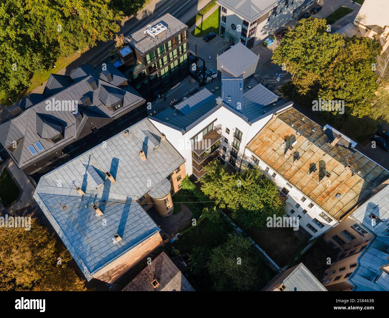 Cluster of modern and older buildings with rusted roofs, surrounded by ...