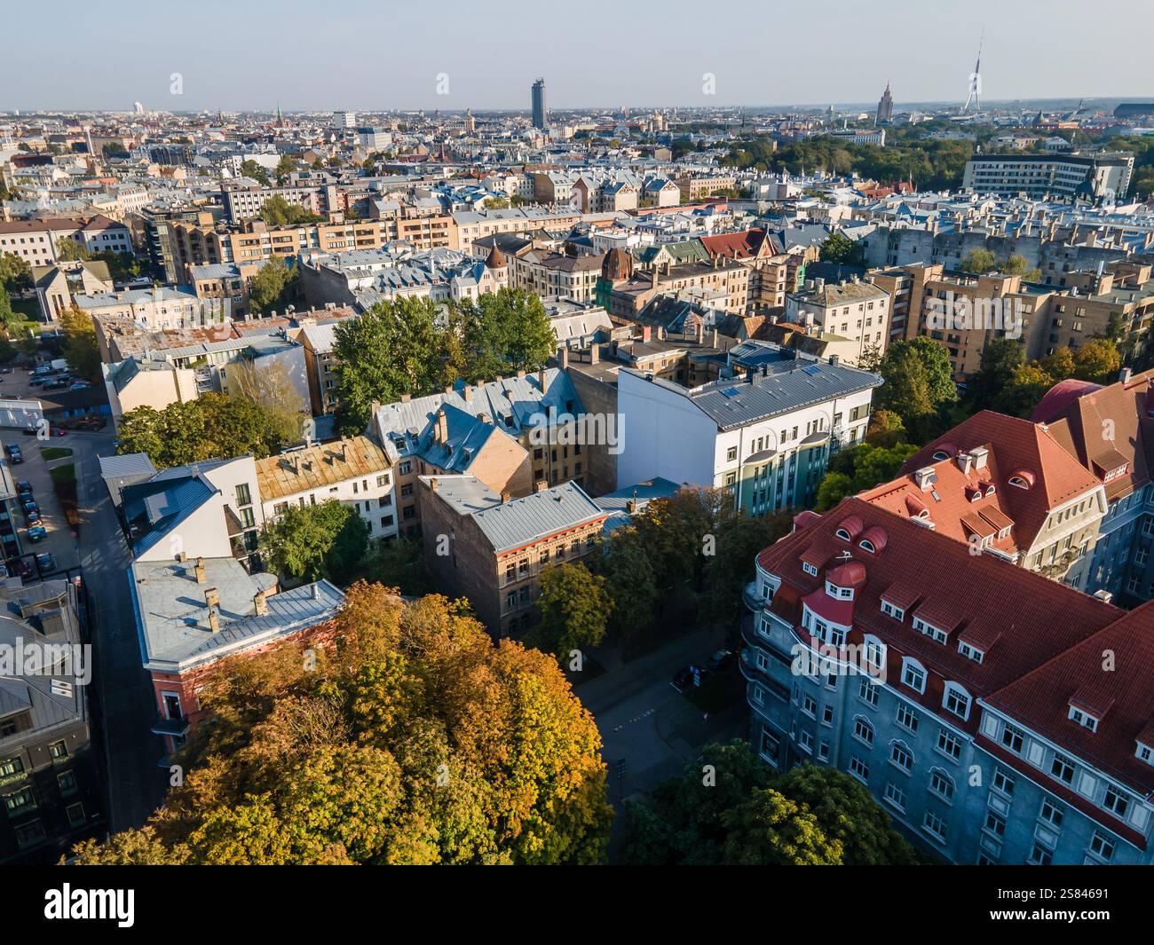 Daylight aerial view of a cityscape featuring red and blue rooftops, a ...
