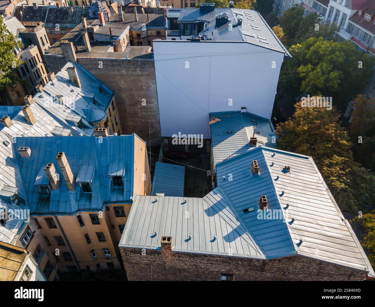 Cluster of historic buildings with blue metal roofs, beige facades, and ...