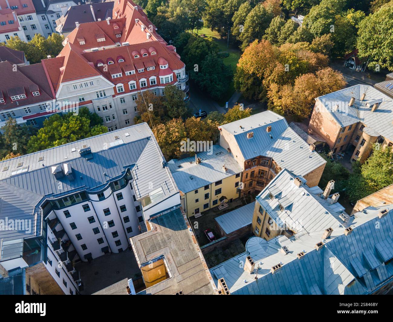Cluster of buildings with red roofs, light facades, and metal roofs ...
