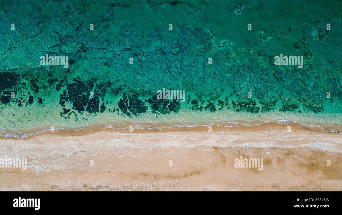 An aerial perspective of a coastline featuring clear turquoise waters ...