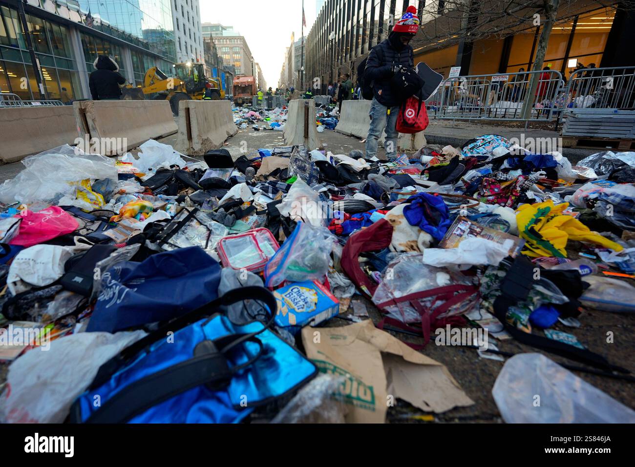 A man looks items among a pile of discarded bags and garbage left ...