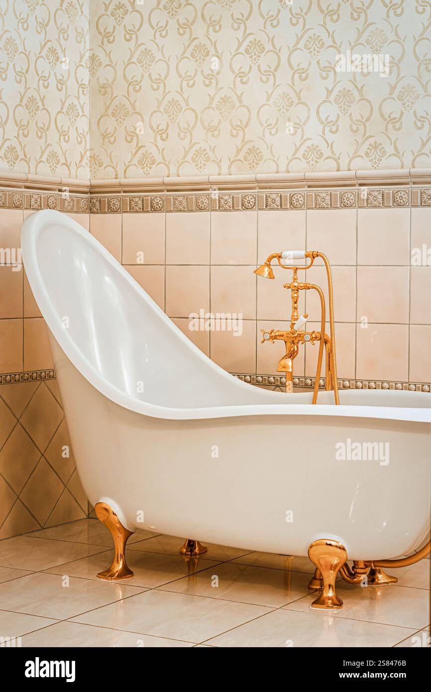 A vintage style bathtub with ornate golden clawfoot legs and matching ...