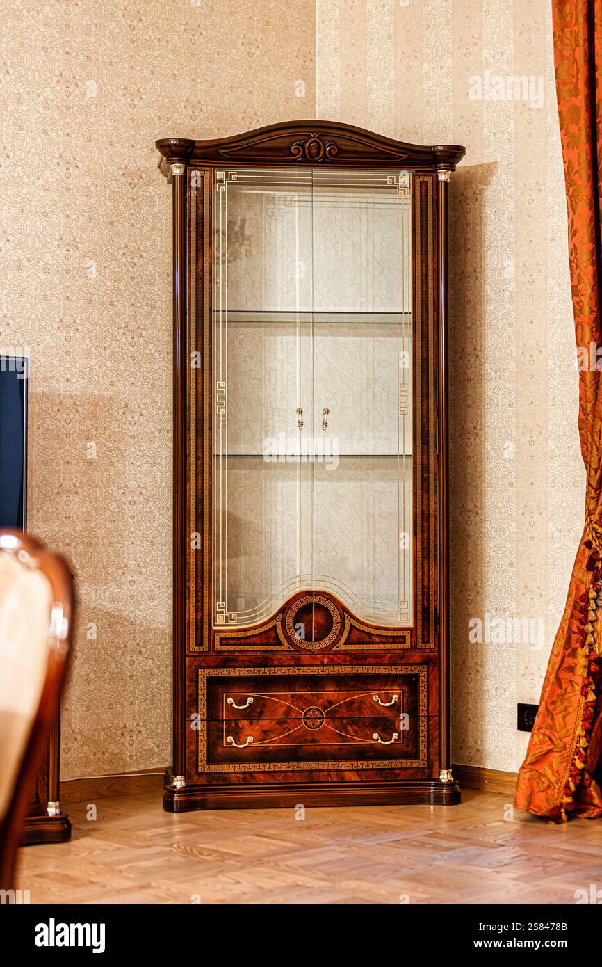 An ornate wooden display cabinet with glass doors and intricate ...