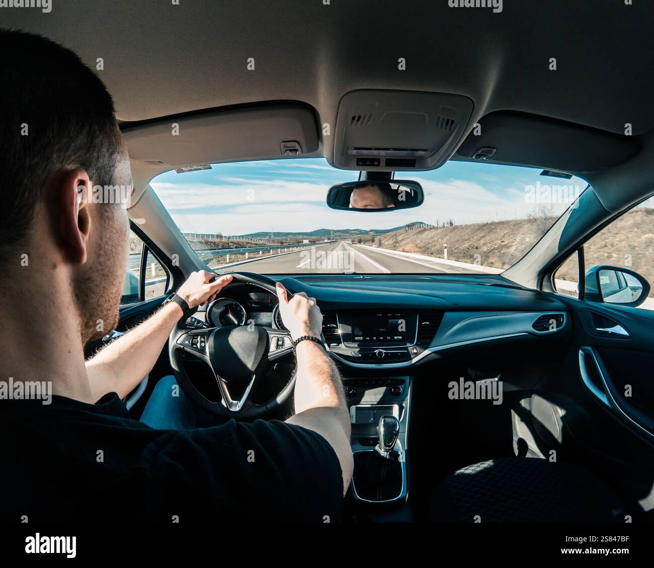Back seat perspective of a car interior showing a man driving on a ...
