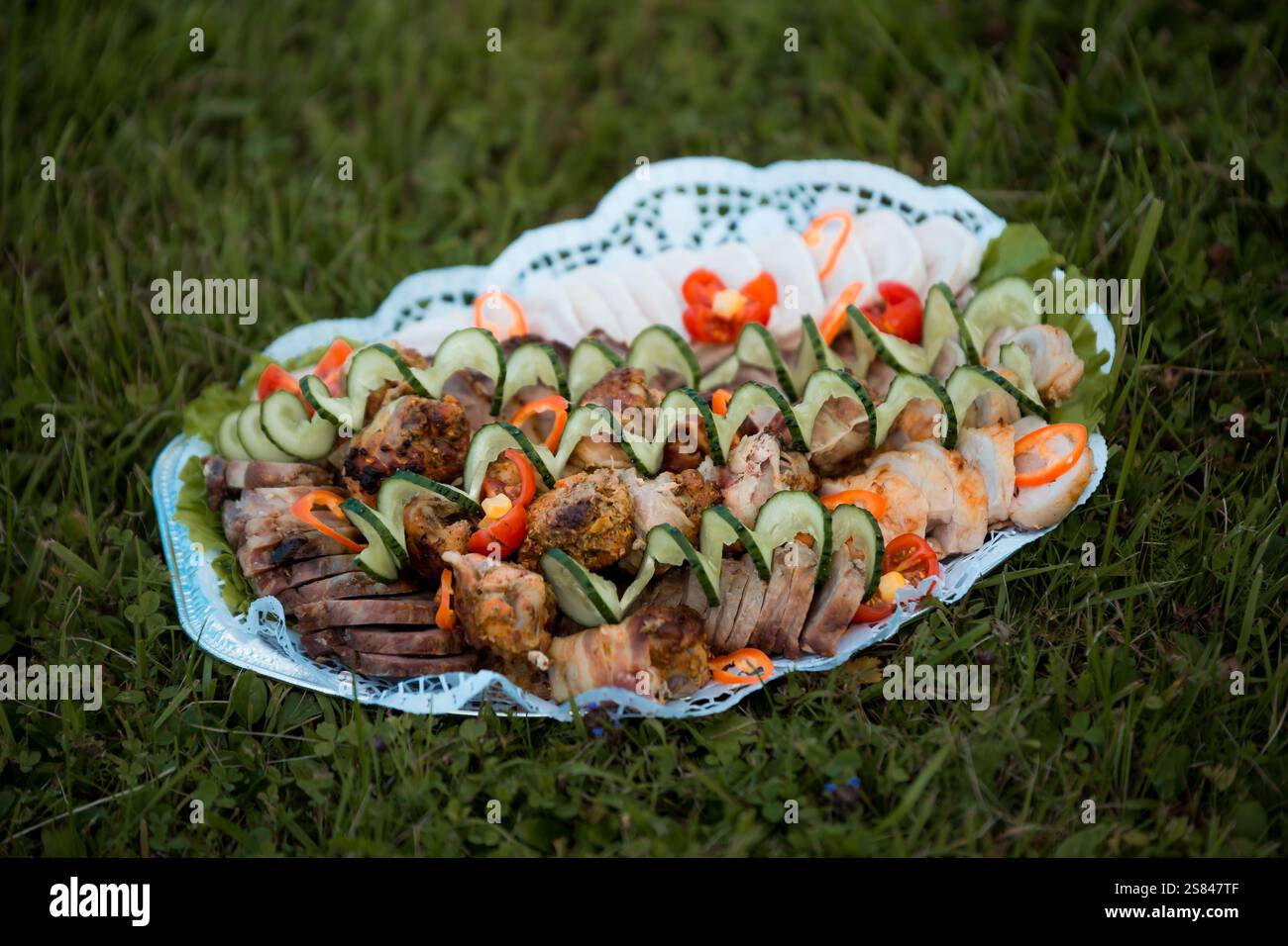 A platter of appetizers with cucumbers, rolled meats, vegetables, and ...