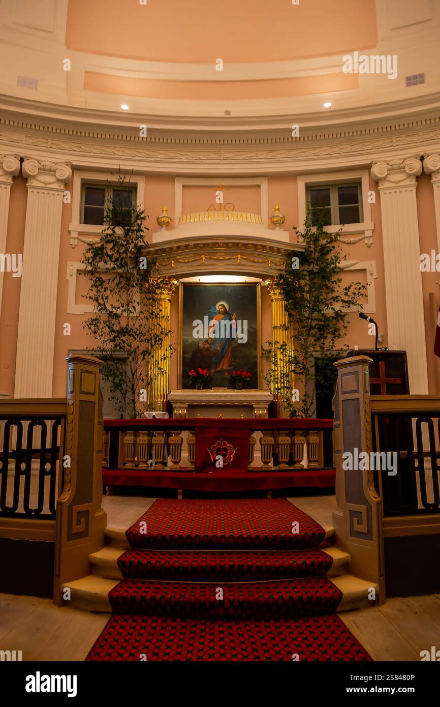 Interior of a church featuring an ornate altar with golden accents, a ...
