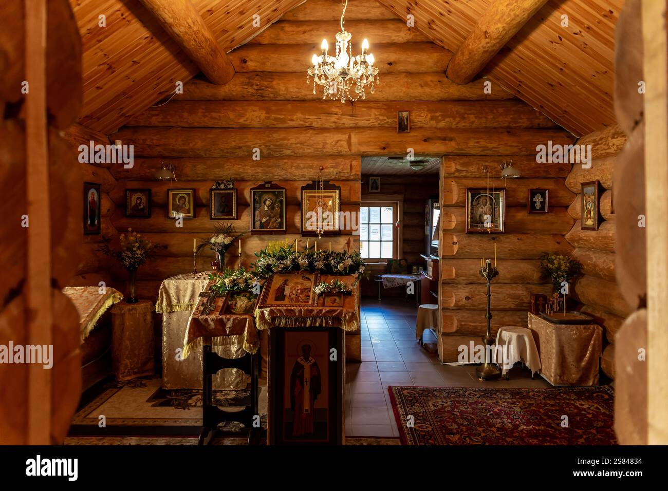 Small wooden chapel featuring log walls, a slanted ceiling, religious ...