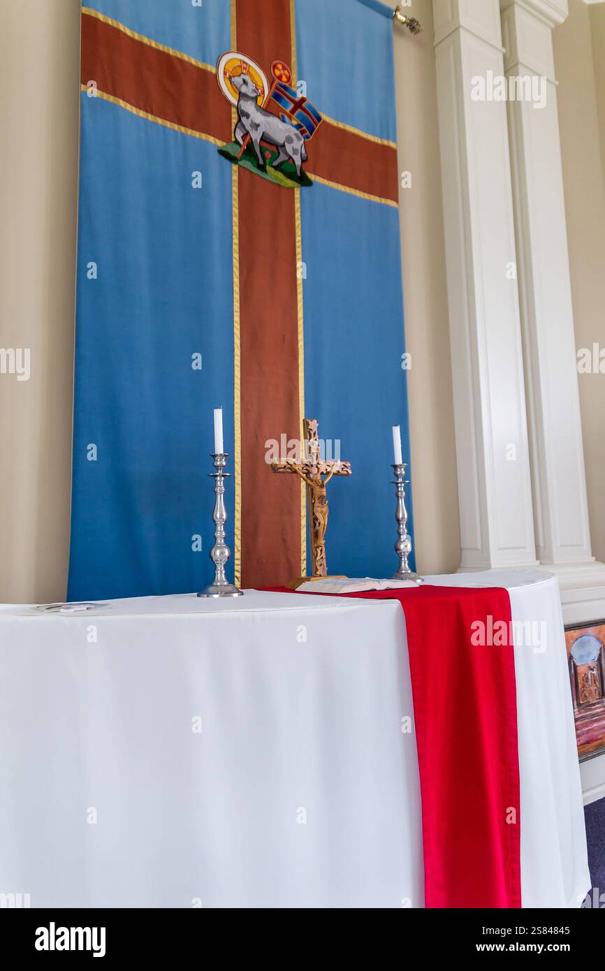 A formal altar setup with a crucifix, candlesticks, and a blue banner ...