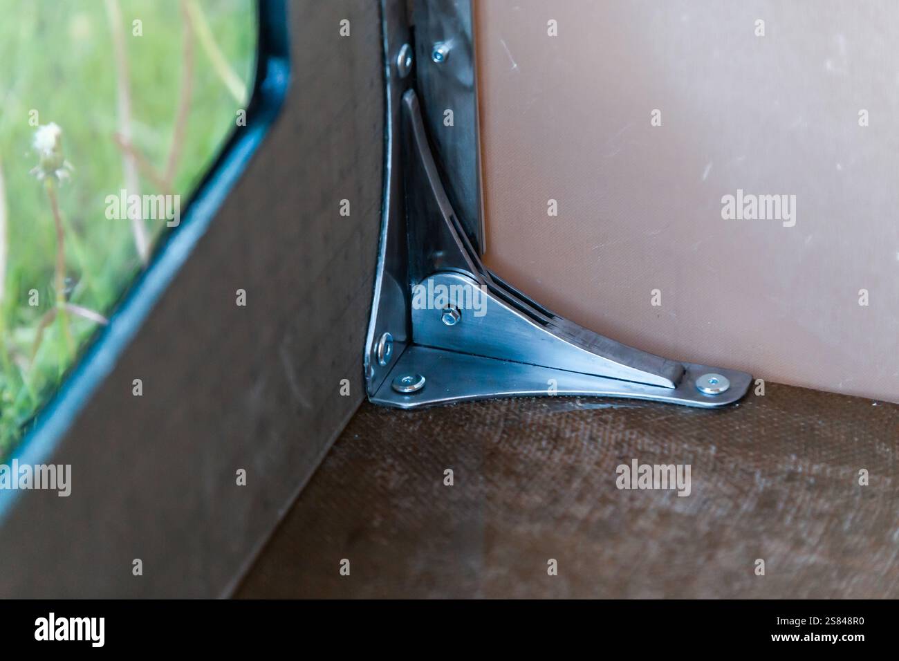 Detailed view of a metal bracket joining two panels, one textured and ...