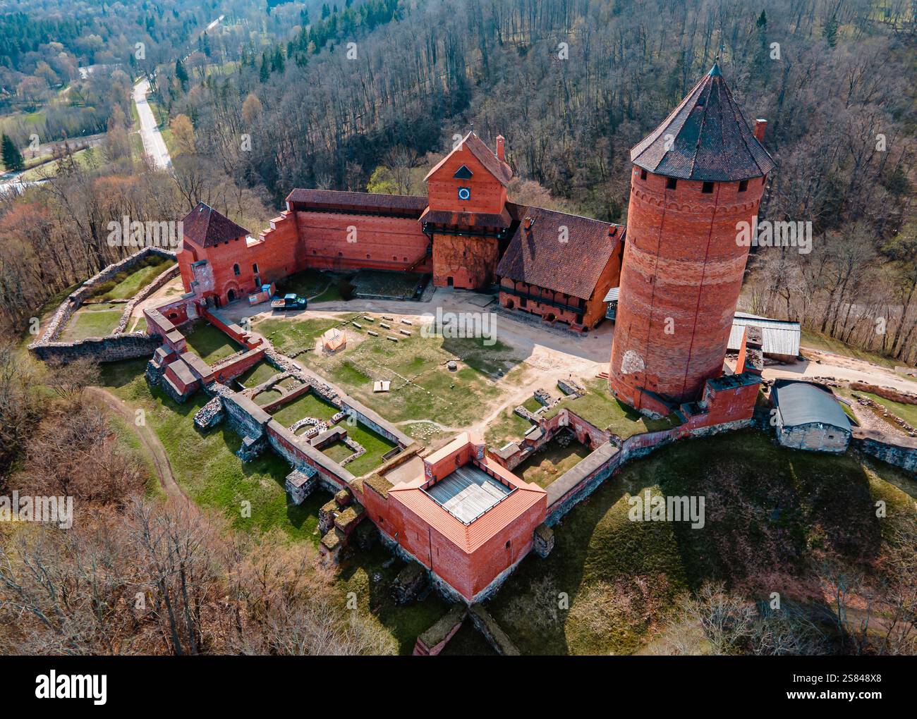 Historic red brick Turaida Castle with a cylindrical tower, stone walls ...