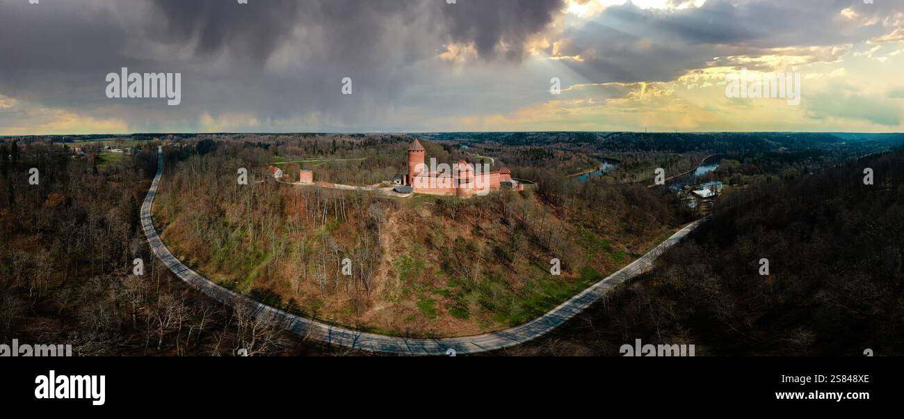 Medieval Turaida Castle with red brick towers on a hill, encircled by a ...