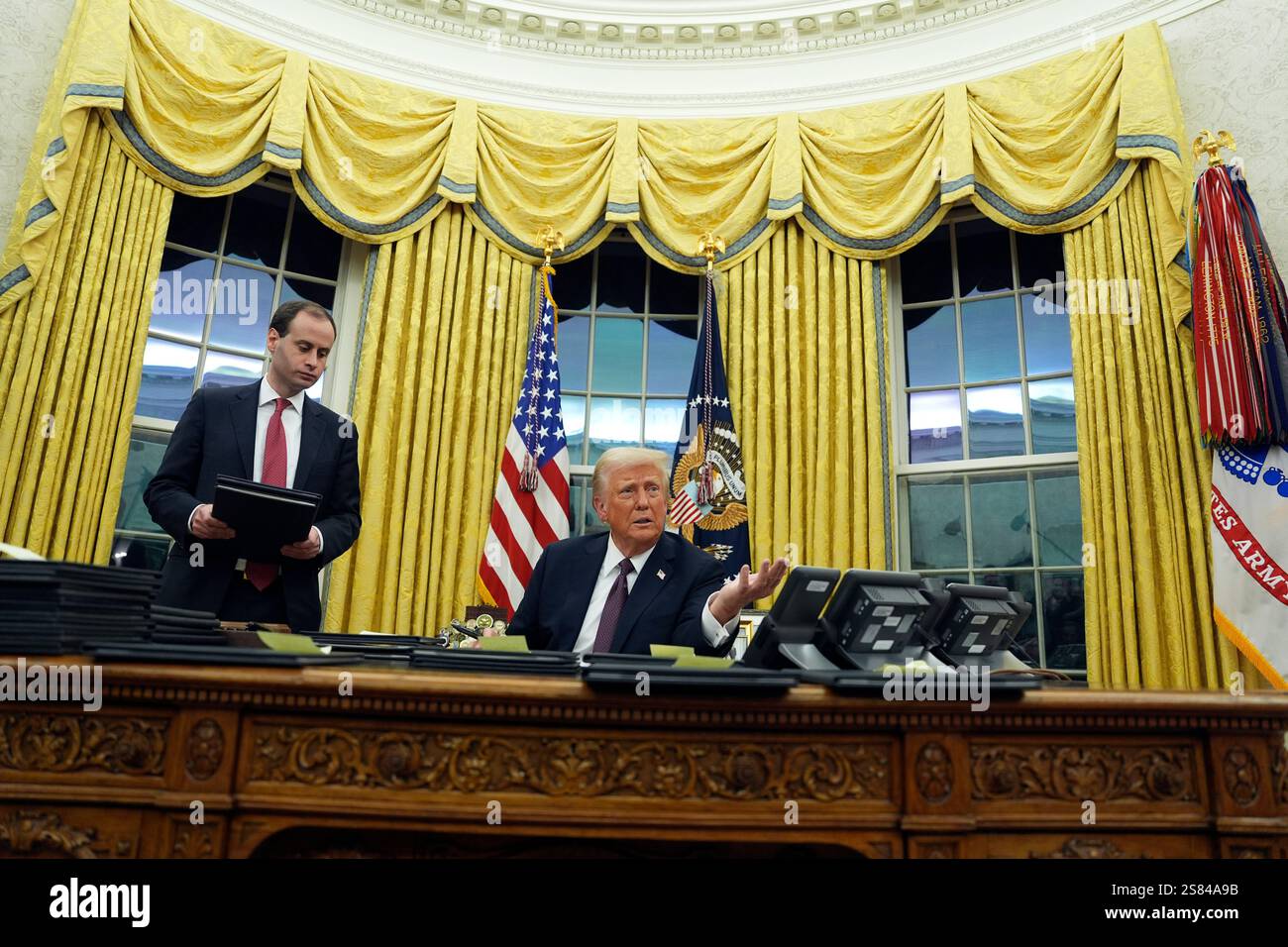 President Donald Trump signs executive orders in the Oval Office of the ...