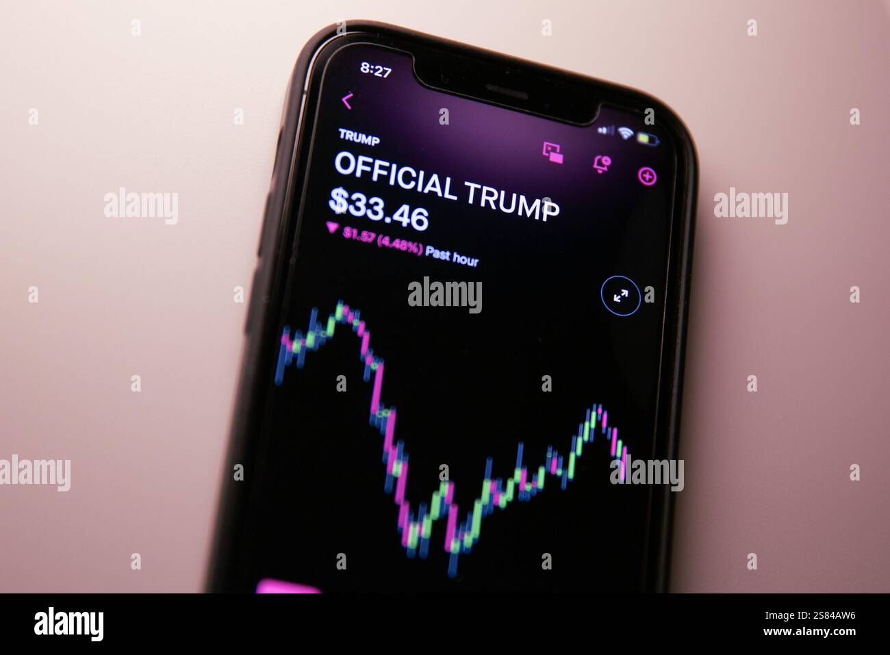A cell phone screen shows the price of TrumpCoin ($TRUMP), President ...