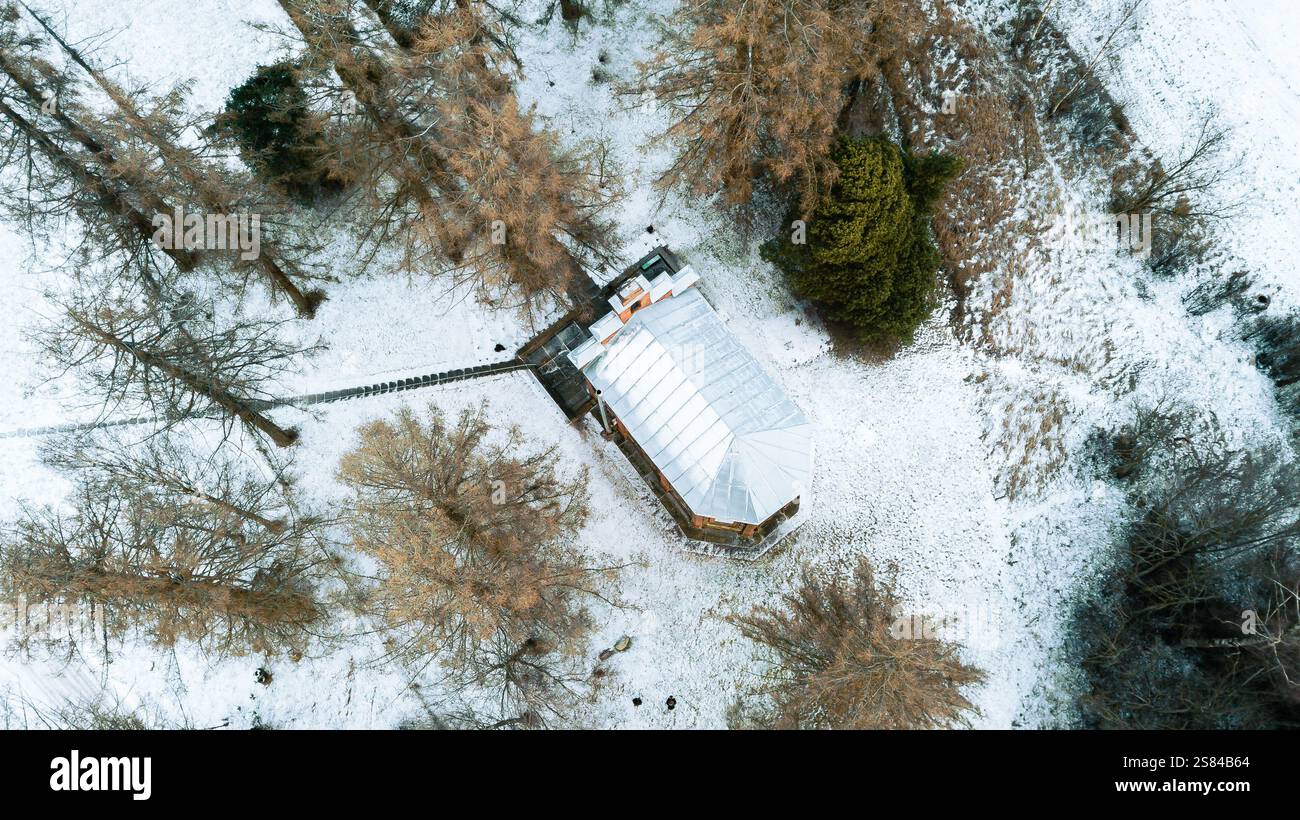 An aerial perspective of a snow covered landscape featuring a small ...