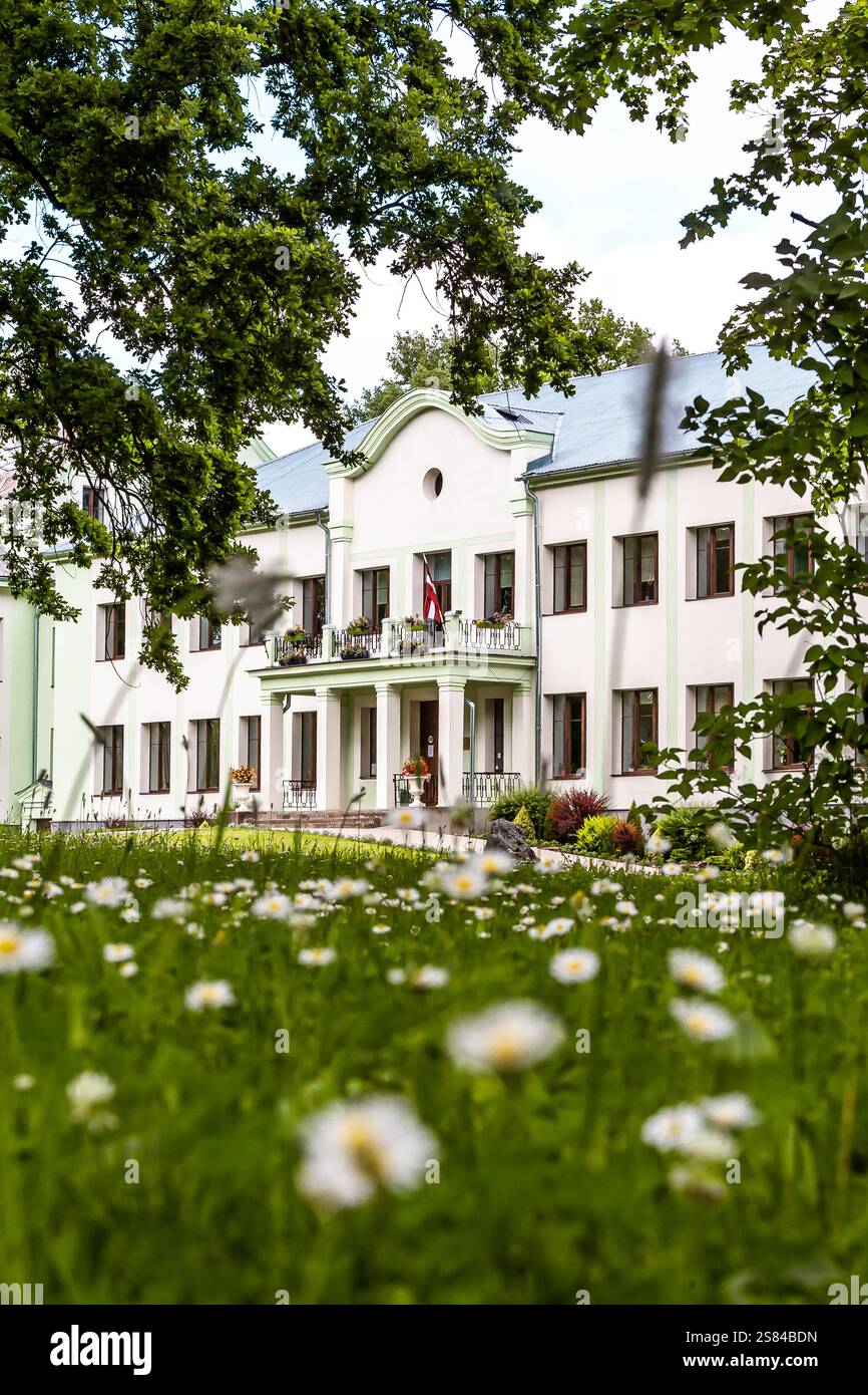 A white symmetrical building with columns and a central balcony ...