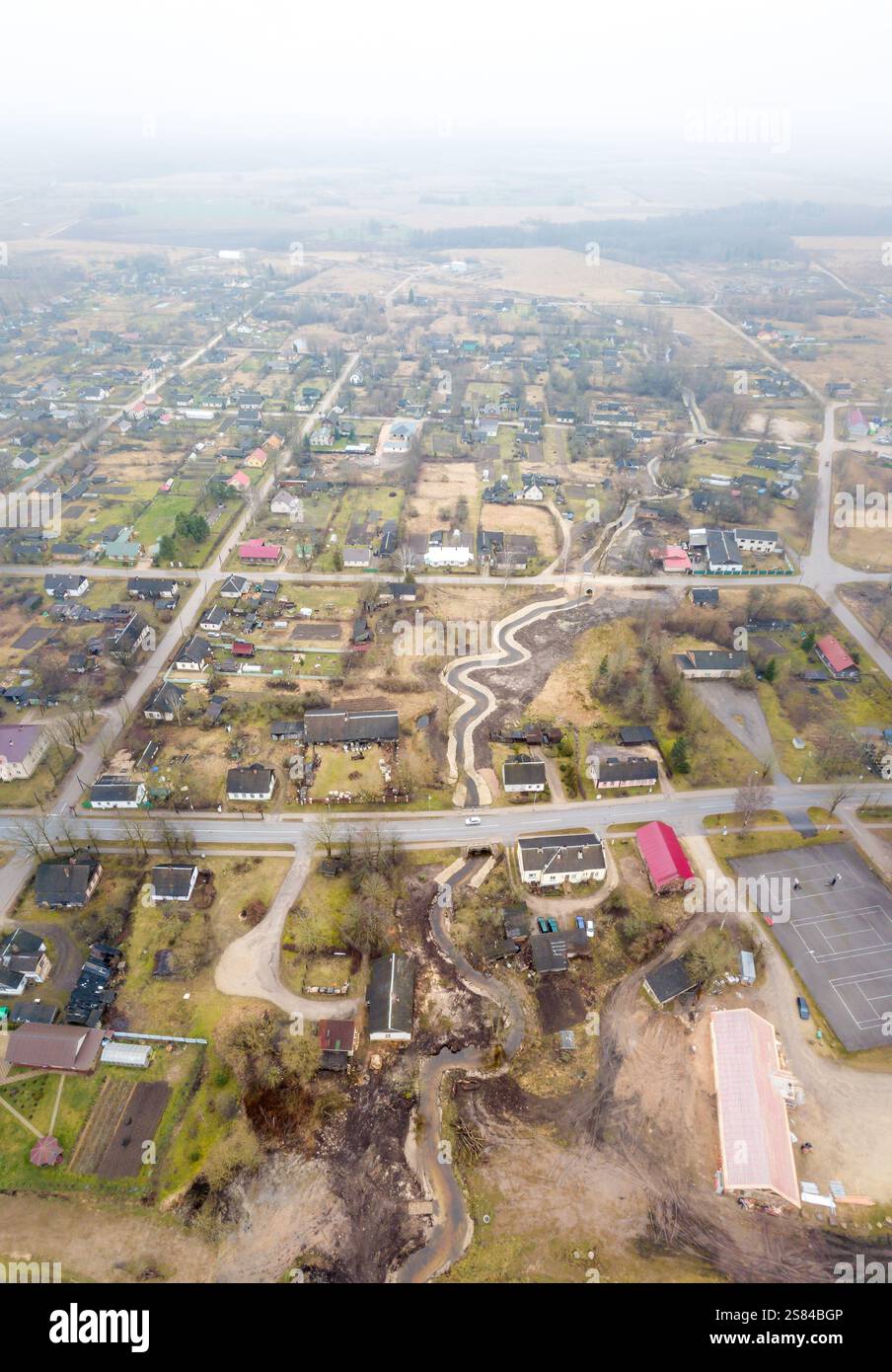 Aerial perspective of a rural village featuring scattered houses, a ...